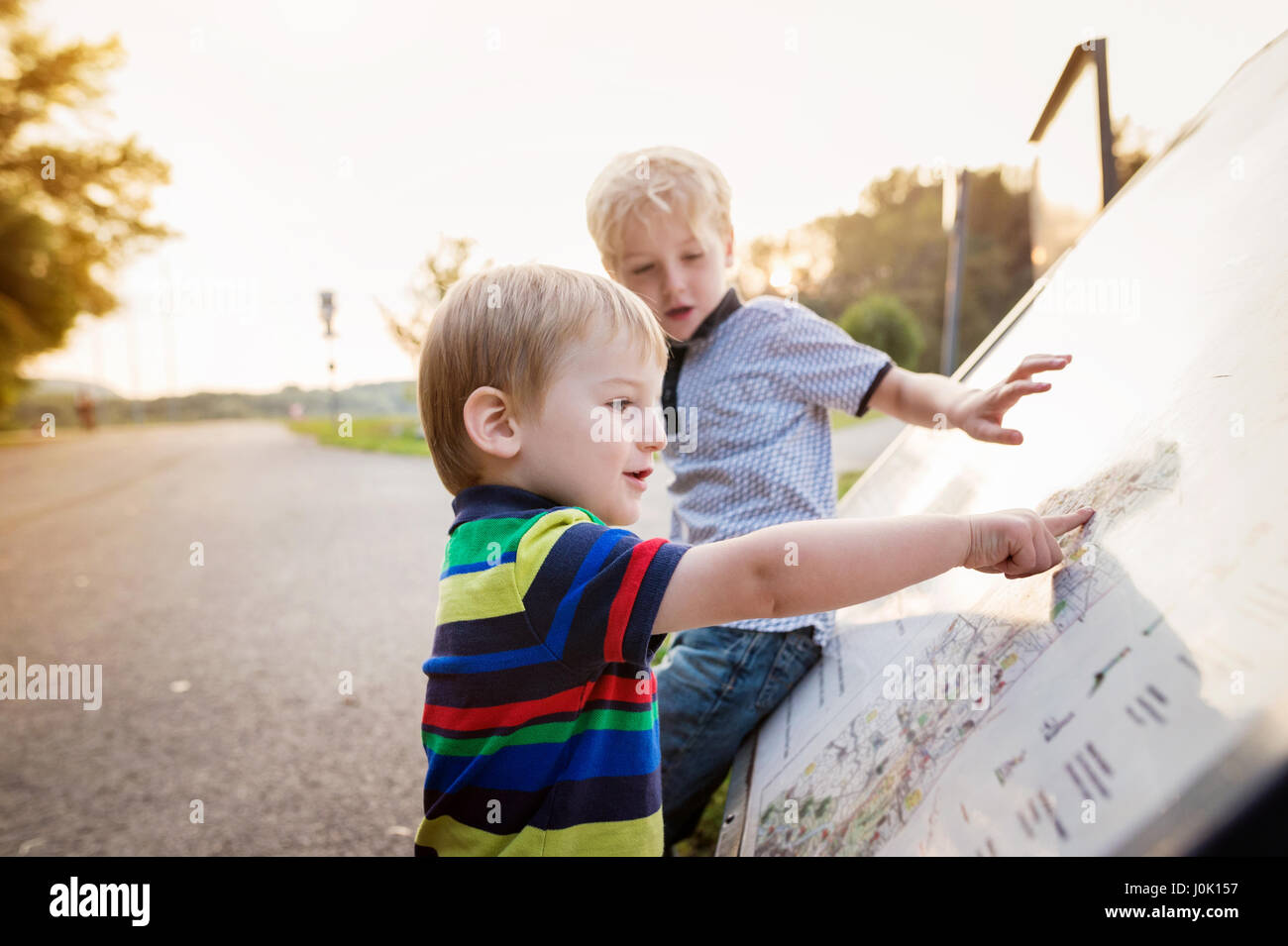 Two little boys reading outdoor map. Warm spring day Stock Photo - Alamy