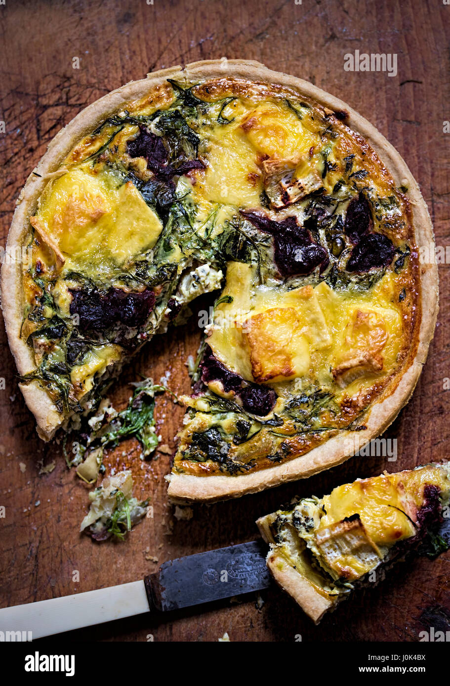 Festive brie, rocket leaves and cranberries quiche Stock Photo - Alamy