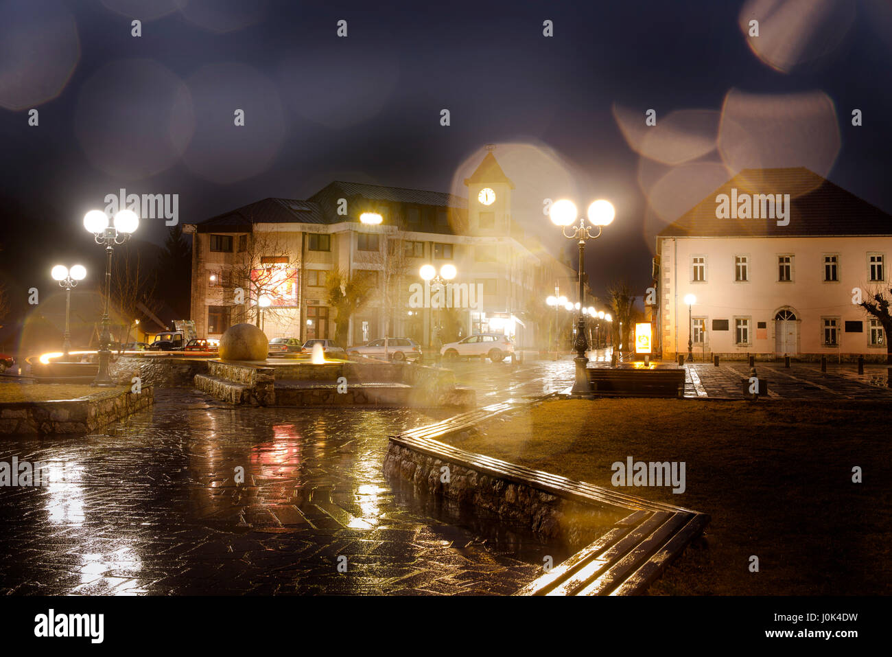 Rain drops in nasty wheather on central square with clock tower ...