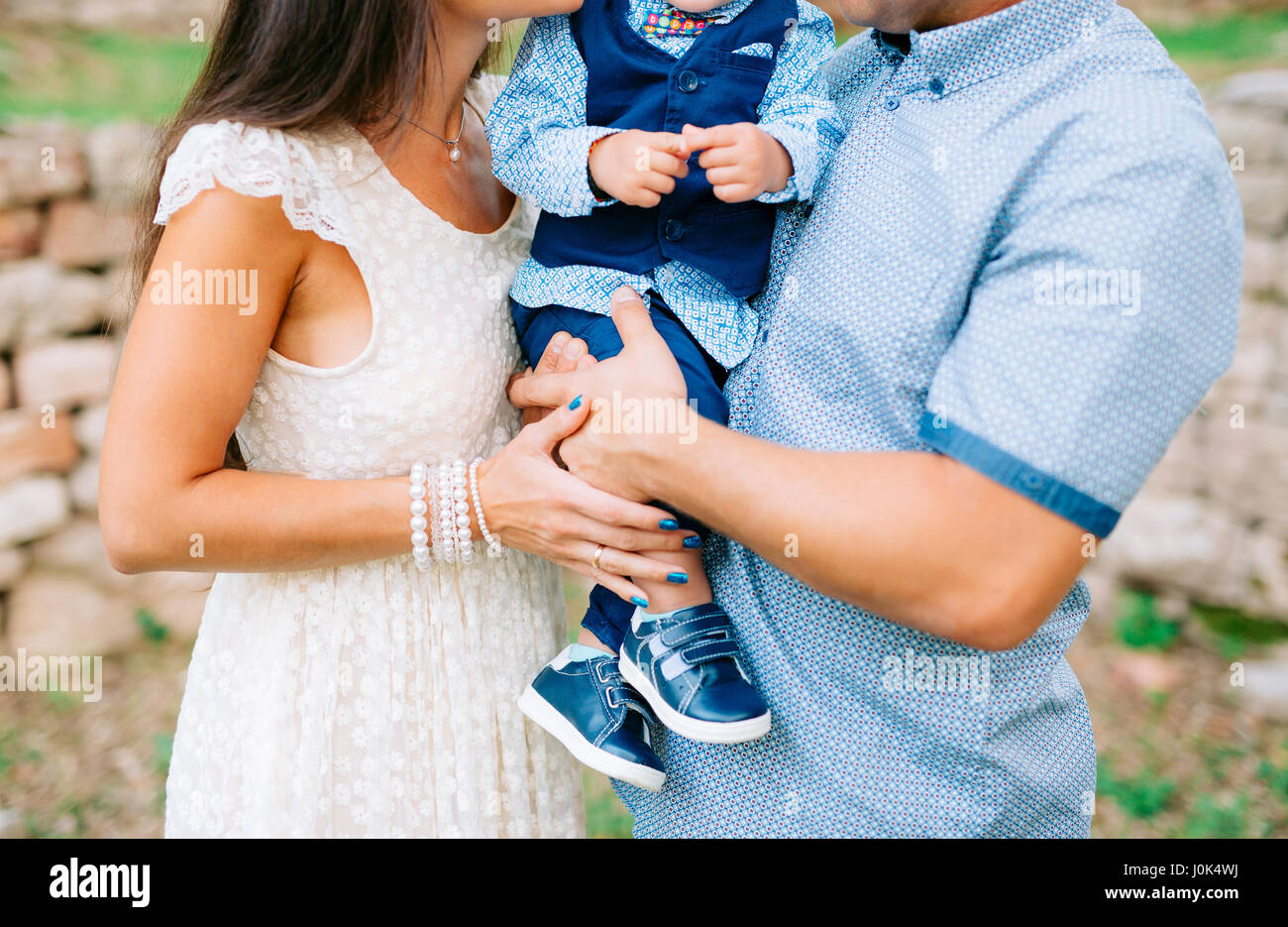 Parents hold the child in their arms. A little child with parents Stock ...