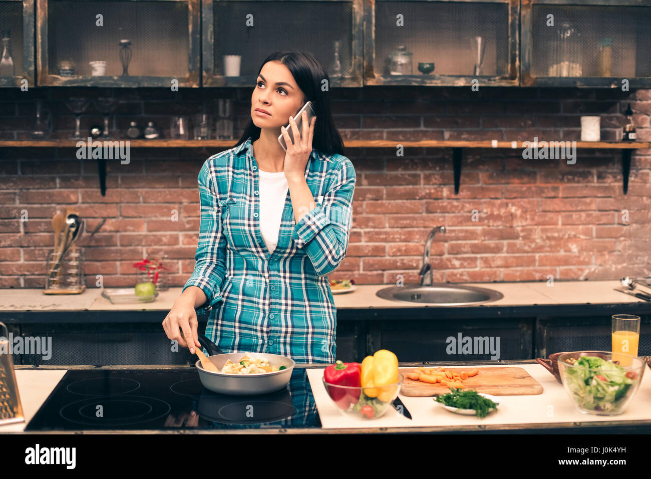Young woman cooking on kitchen Stock Photo - Alamy