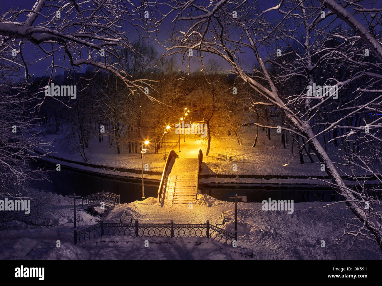 Winter night cityscape with the Yauza river and lanterns-lit alley ...