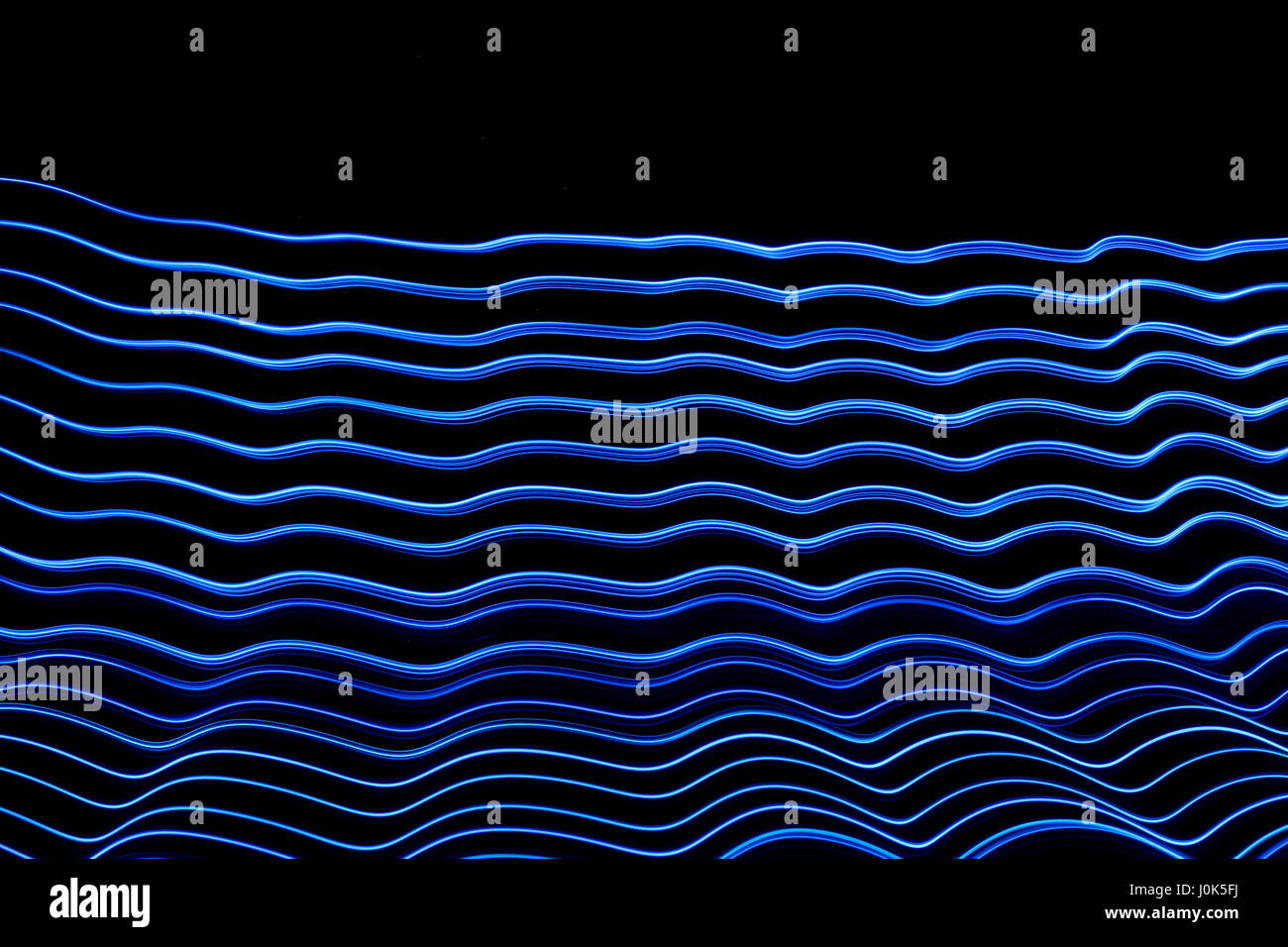 Long exposure photograph of neon electric blue colour in an abstract ...