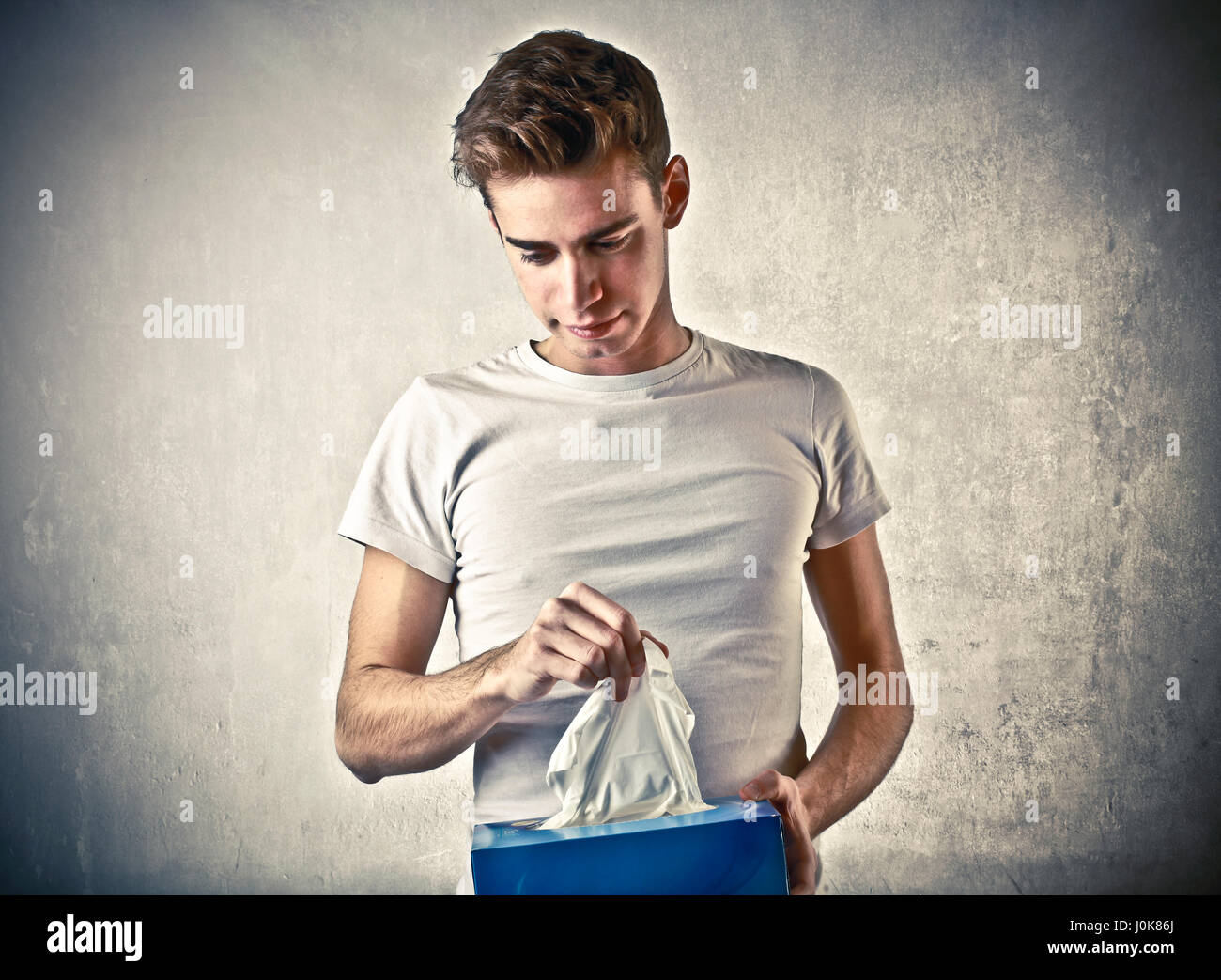 Crying man using tissues Stock Photo - Alamy