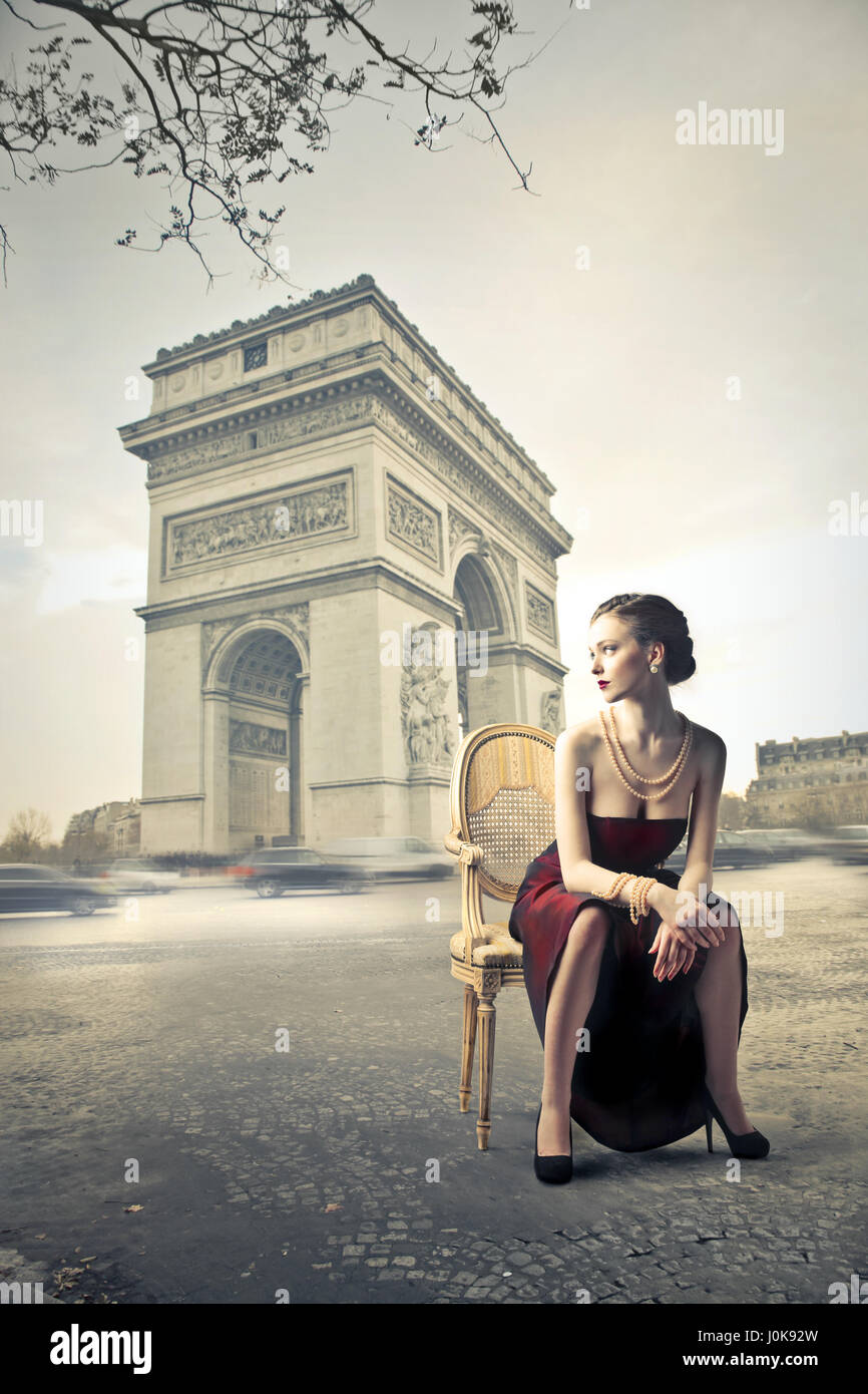 Elegant woman sitting in front of the Notre Dam Stock Photo - Alamy