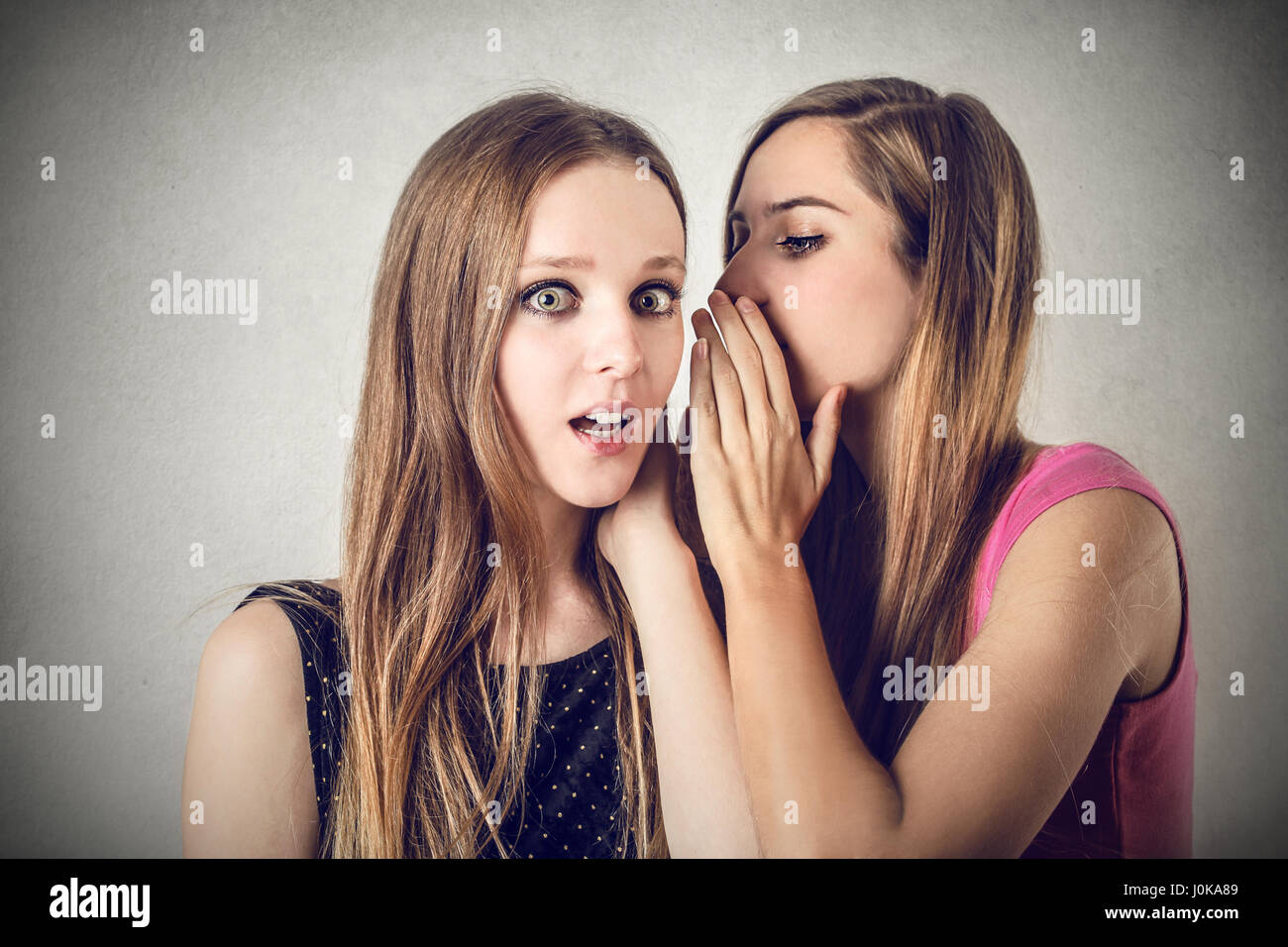 2 girls sharing secrets Stock Photo - Alamy