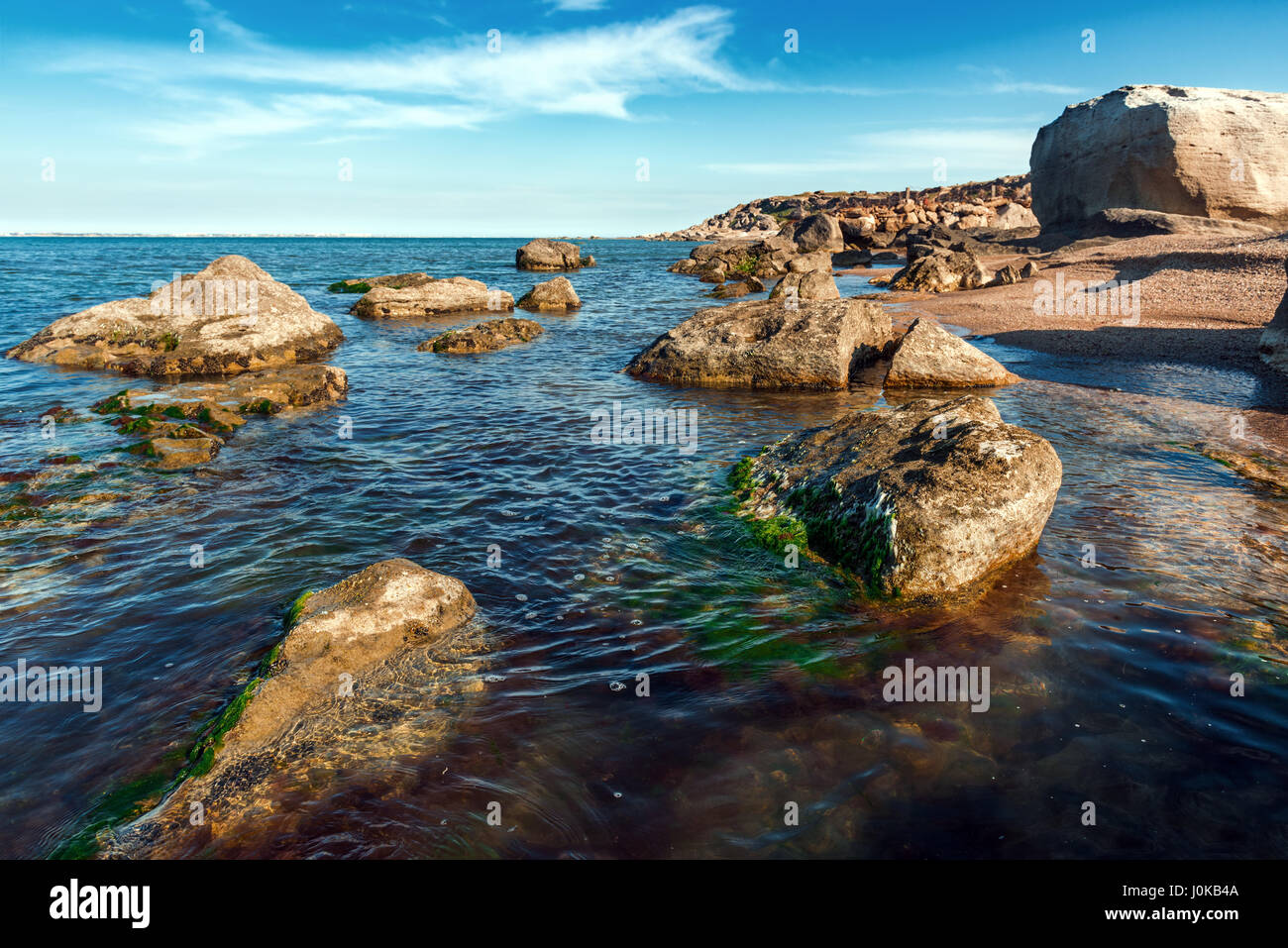 Coast with rocks and blue water Stock Photo - Alamy