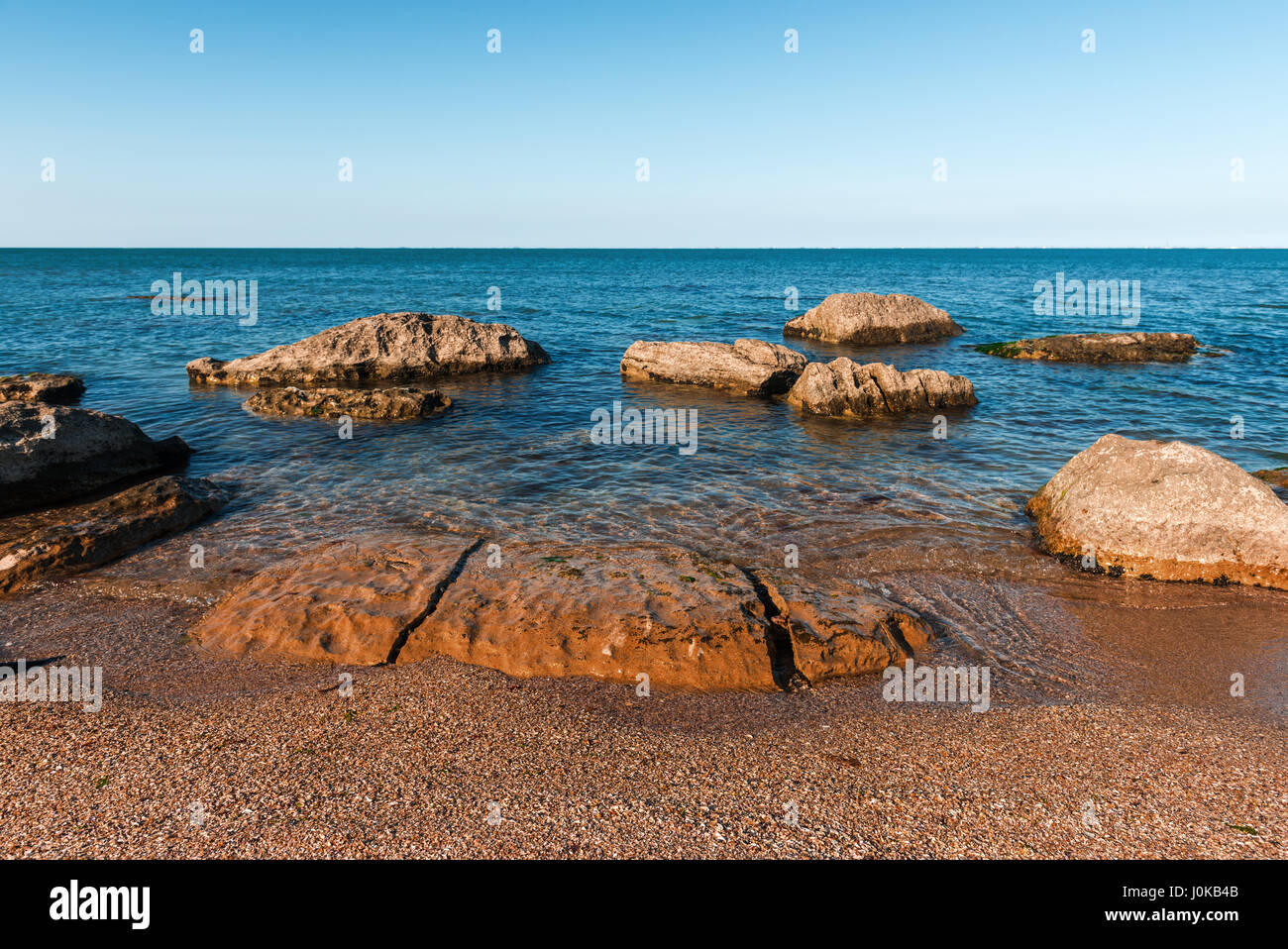 Coast with rocks and blue water Stock Photo - Alamy