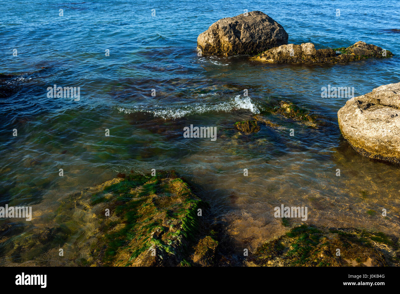 Coast with rocks and blue water Stock Photo - Alamy