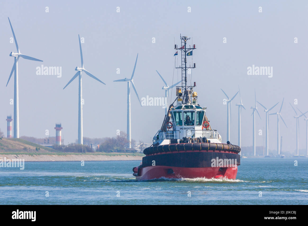 Rotterdam, the Netherlands - April 9, 2017: tug boat and wind turbines ...