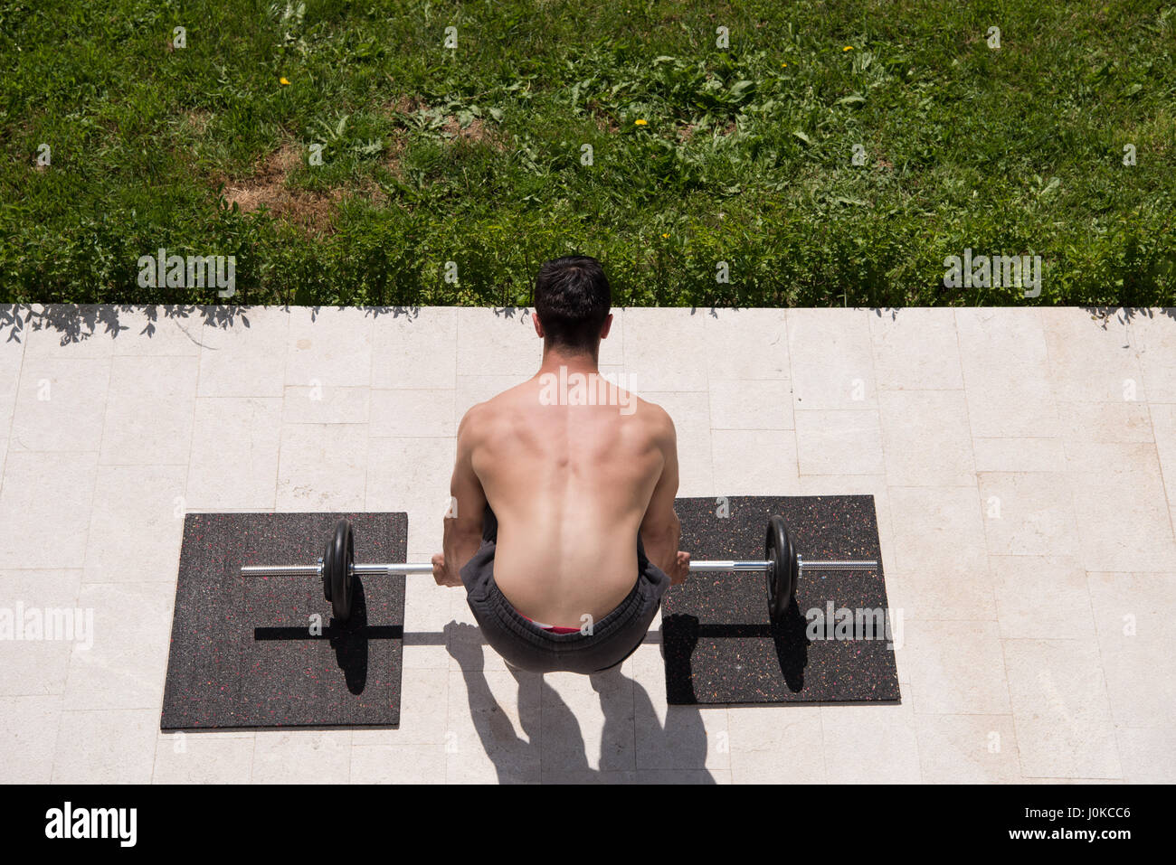 young handsome man doing morning exercises in front of his luxury home ...