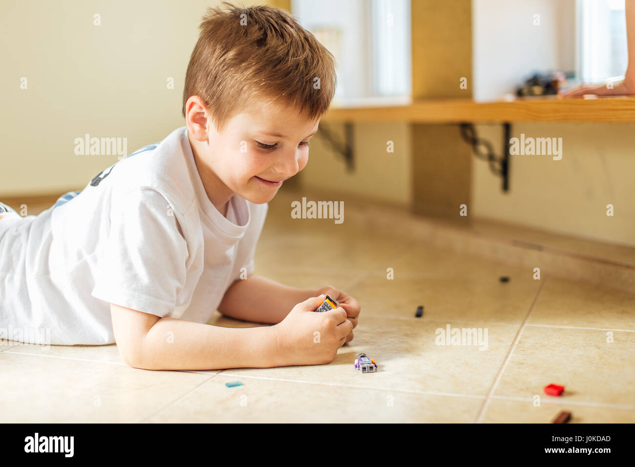 Two boys playing with lego at home with light from window background ...