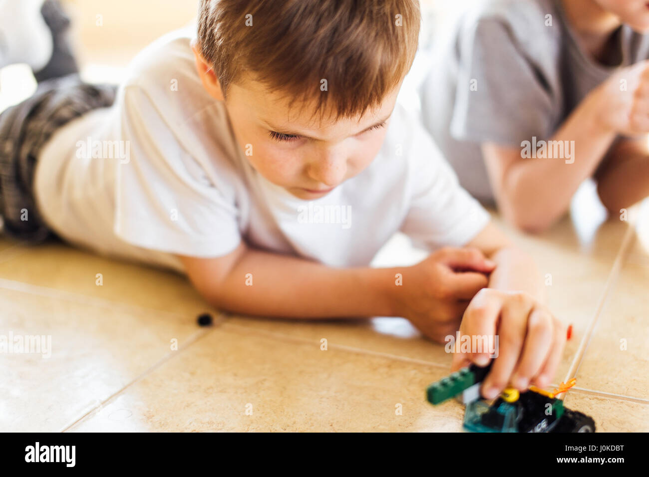 Two boys playing with lego at home with light from window background ...