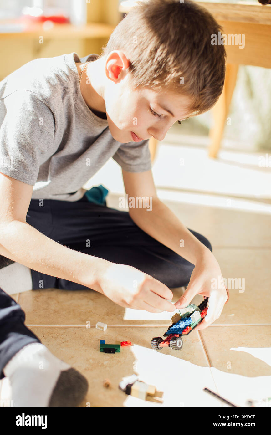 Two boys playing with lego at home with light from window background ...