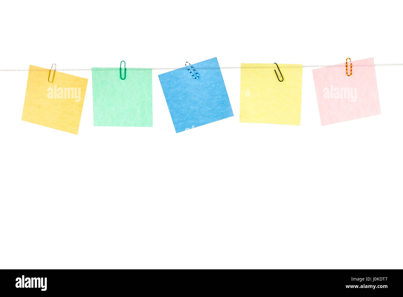 Colored yellow, green, blue, red stickers with paper clips hanging on a ...