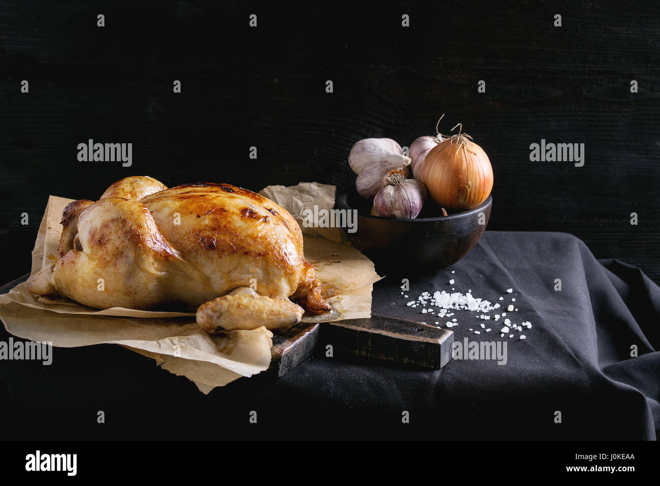 Grilled baked whole organic chicken on backing paper wooden chopping ...
