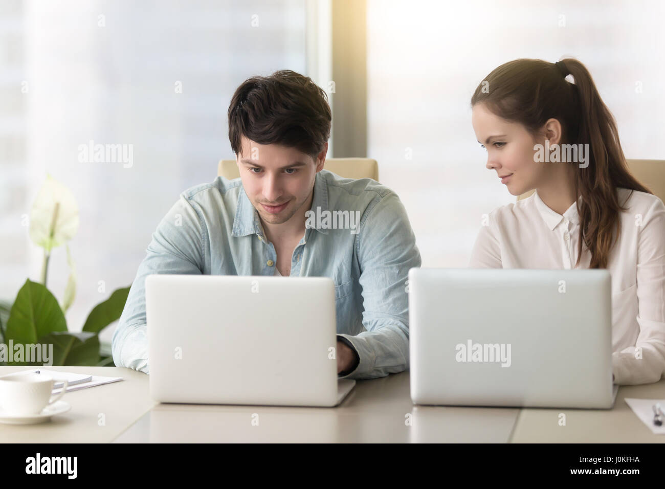 Curious Female Spying Male Colleague Working On Laptop Sneakin Stock