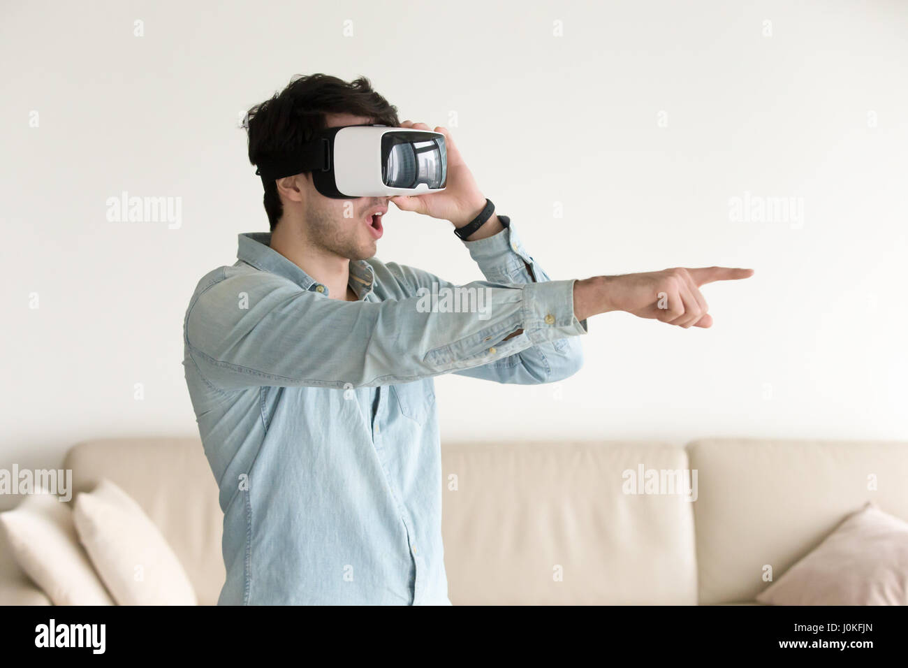 Excited young guy experiencing virtual reality wearing VR headse Stock ...