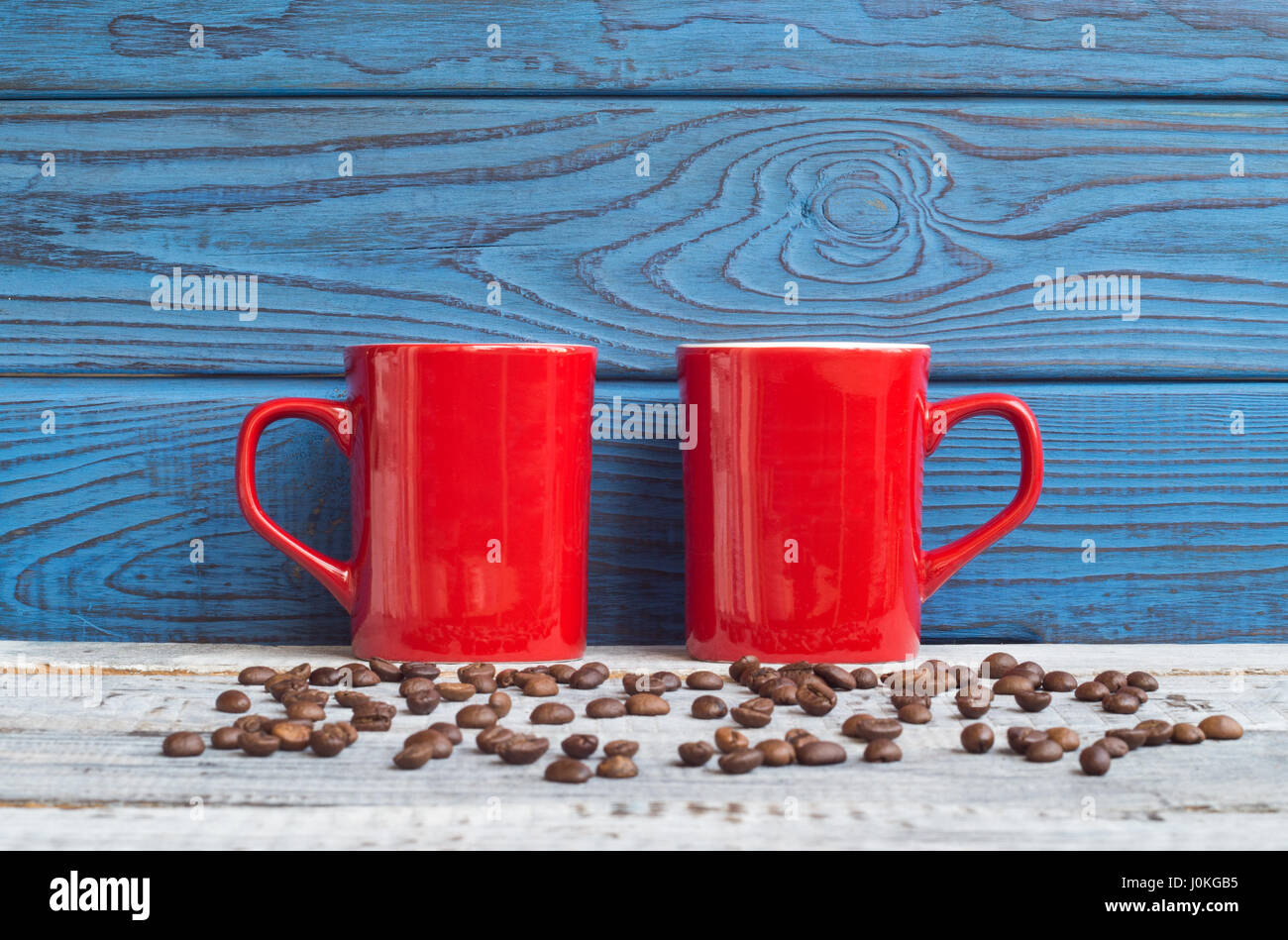 Two red cups and coffee beans on background of blue boards Stock Photo ...