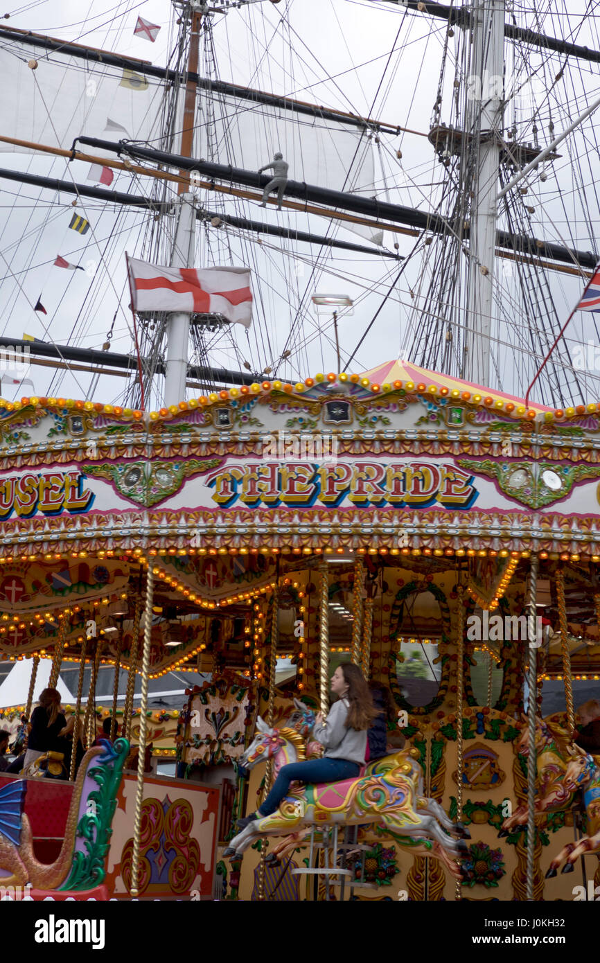 Tourists at merry-go-round with Cutty Sark in background during ...