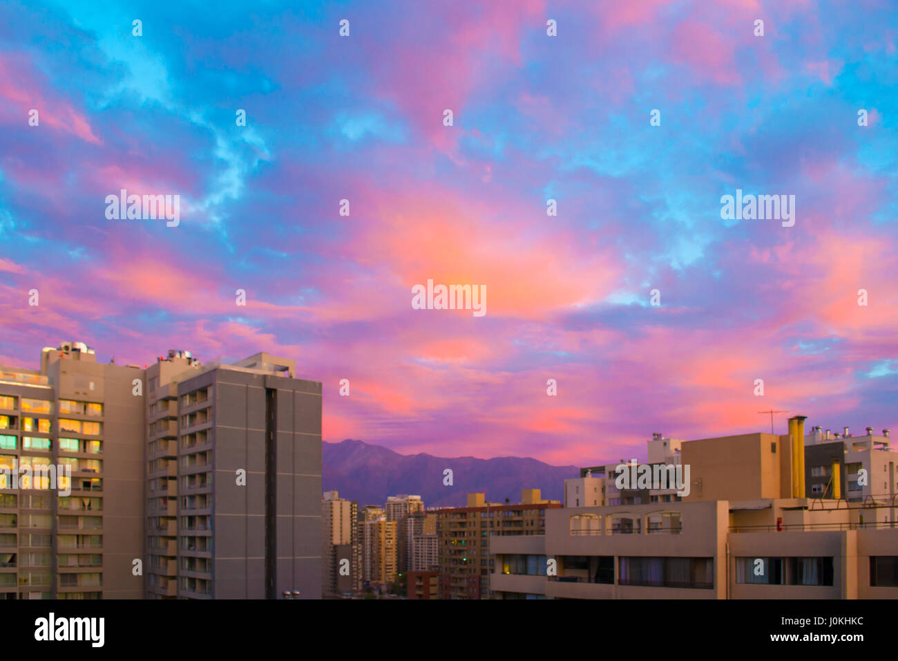 Sunset with blue sky and pink clouds above buildings Stock Photo - Alamy