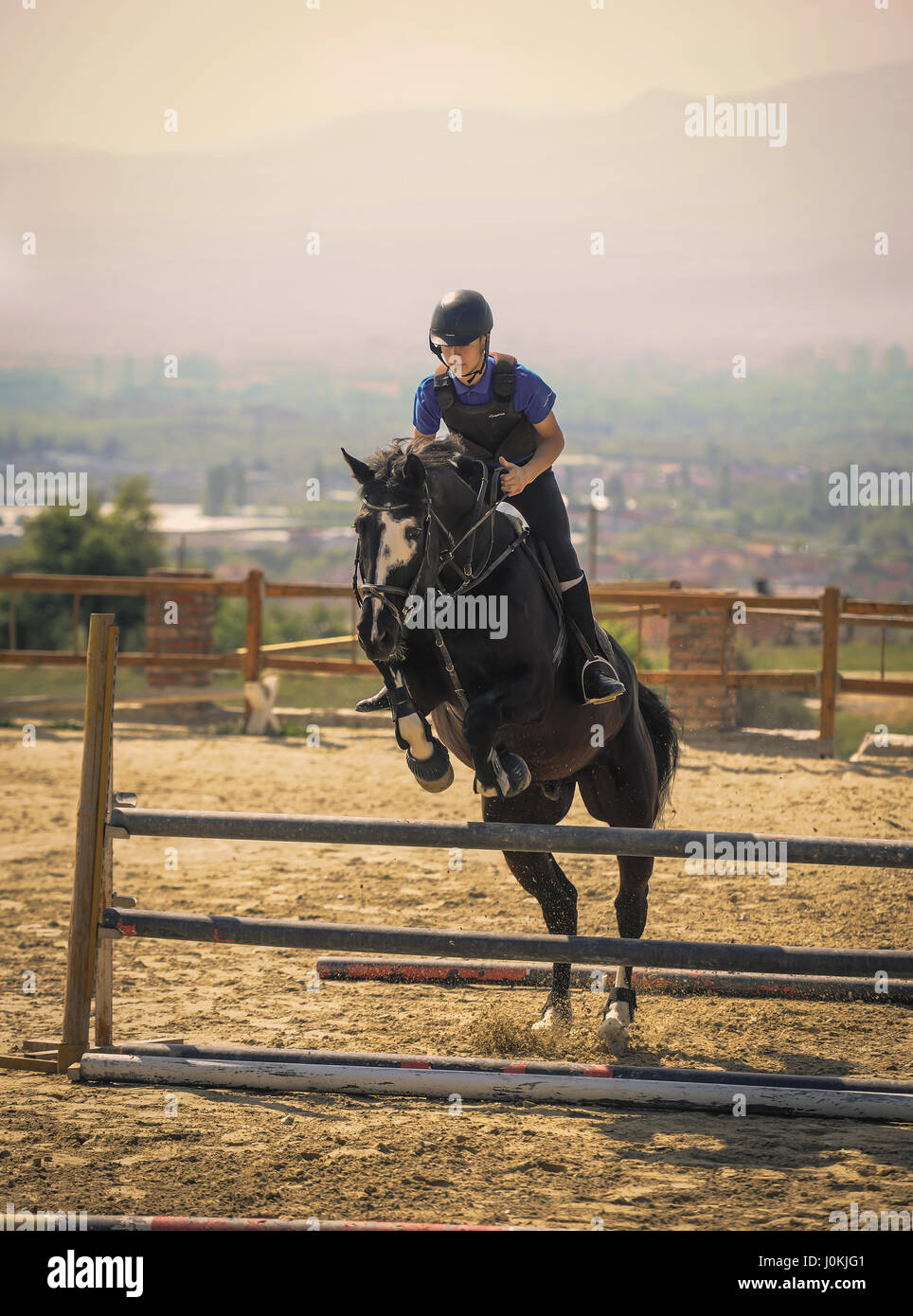 Equestrian sports Black horse approaching. Jockey riding a fast ...