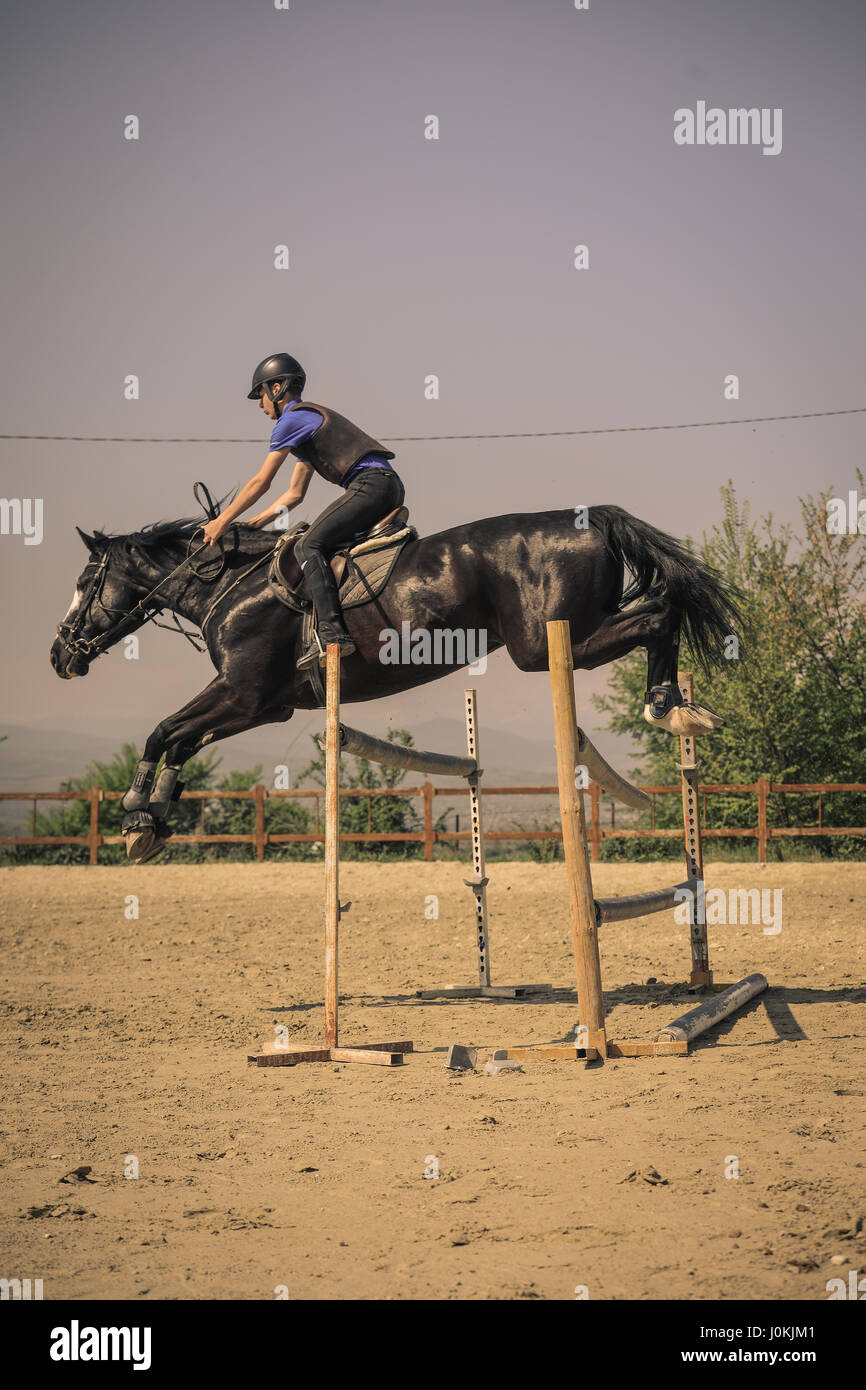 Equestrian sports Black horse approaching. Jockey riding a fast ...