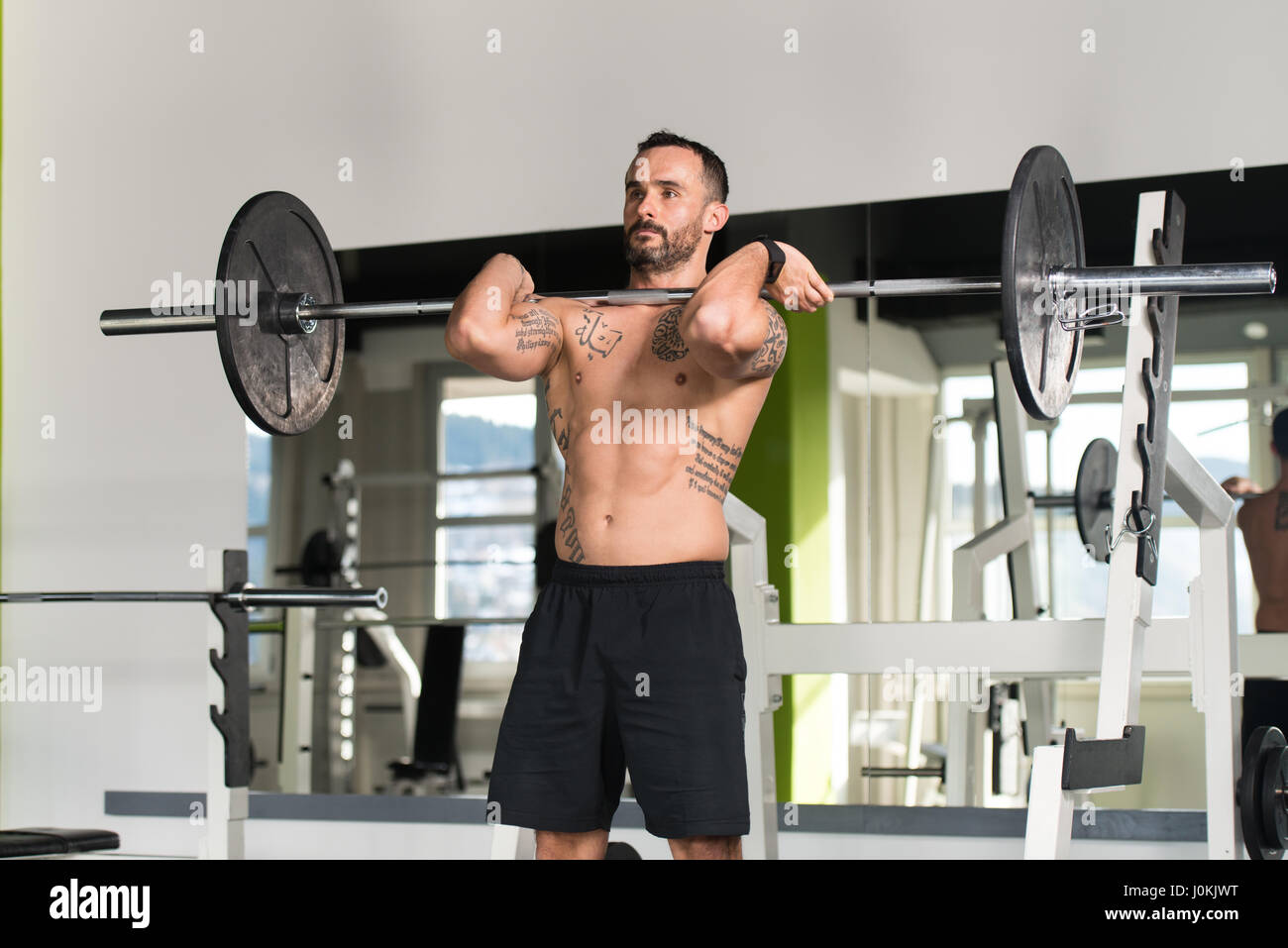Man Working Out Legs With Barbell In A Gym - Front Squat Exercise Stock ...
