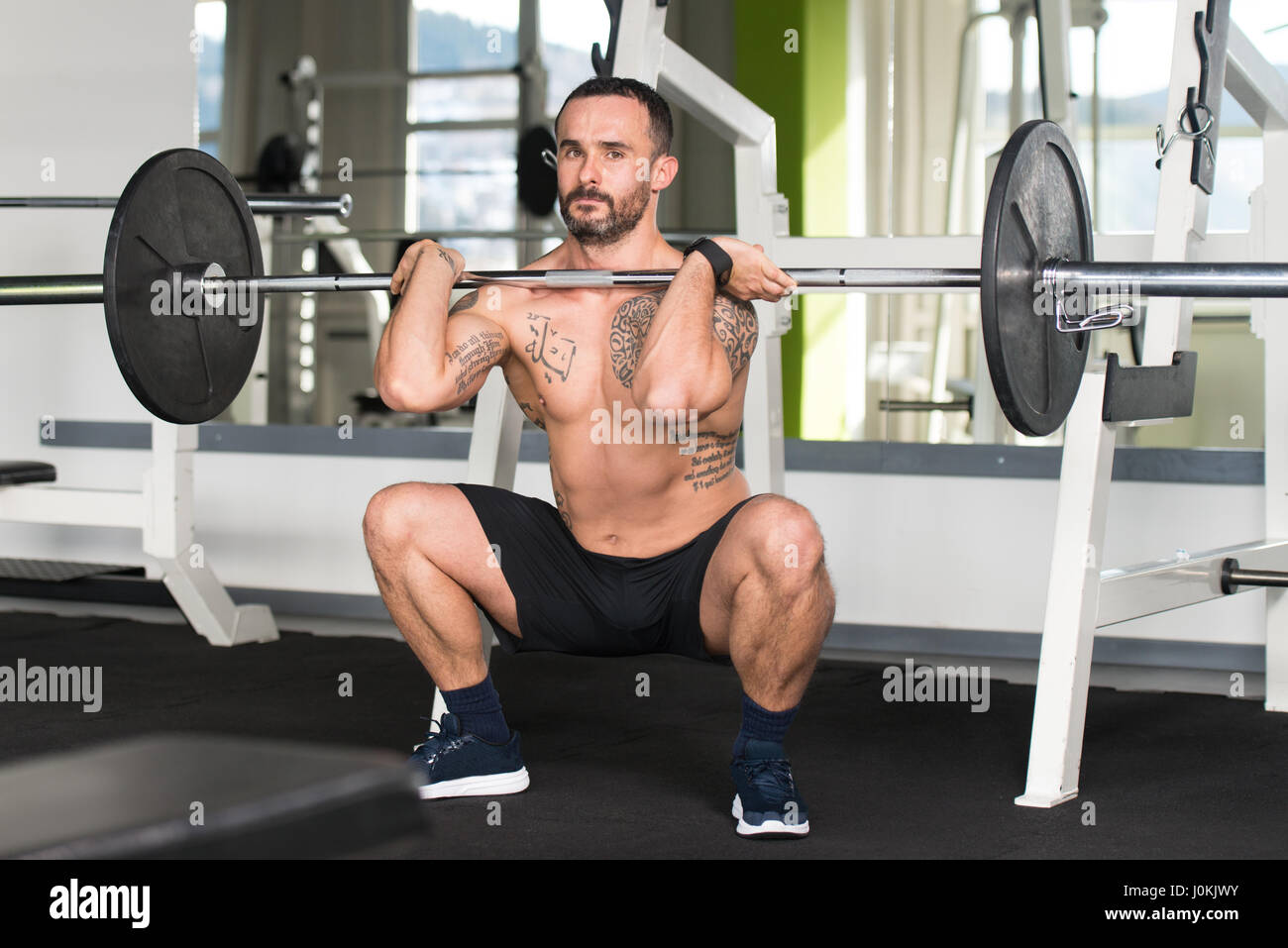Man Working Out Legs With Barbell In A Gym - Front Squat Exercise Stock ...