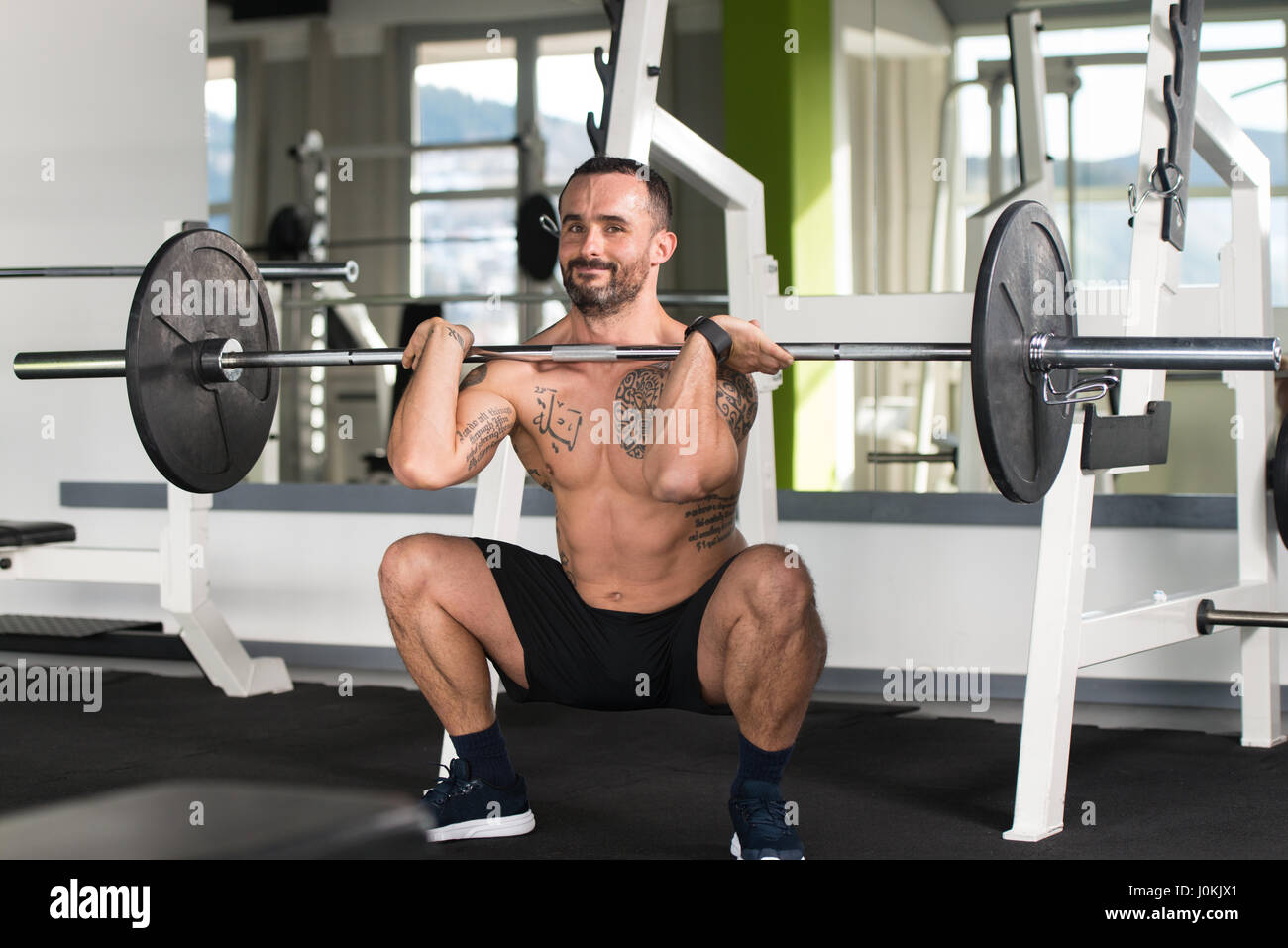 Man Working Out Legs With Barbell In A Gym - Front Squat Exercise Stock ...