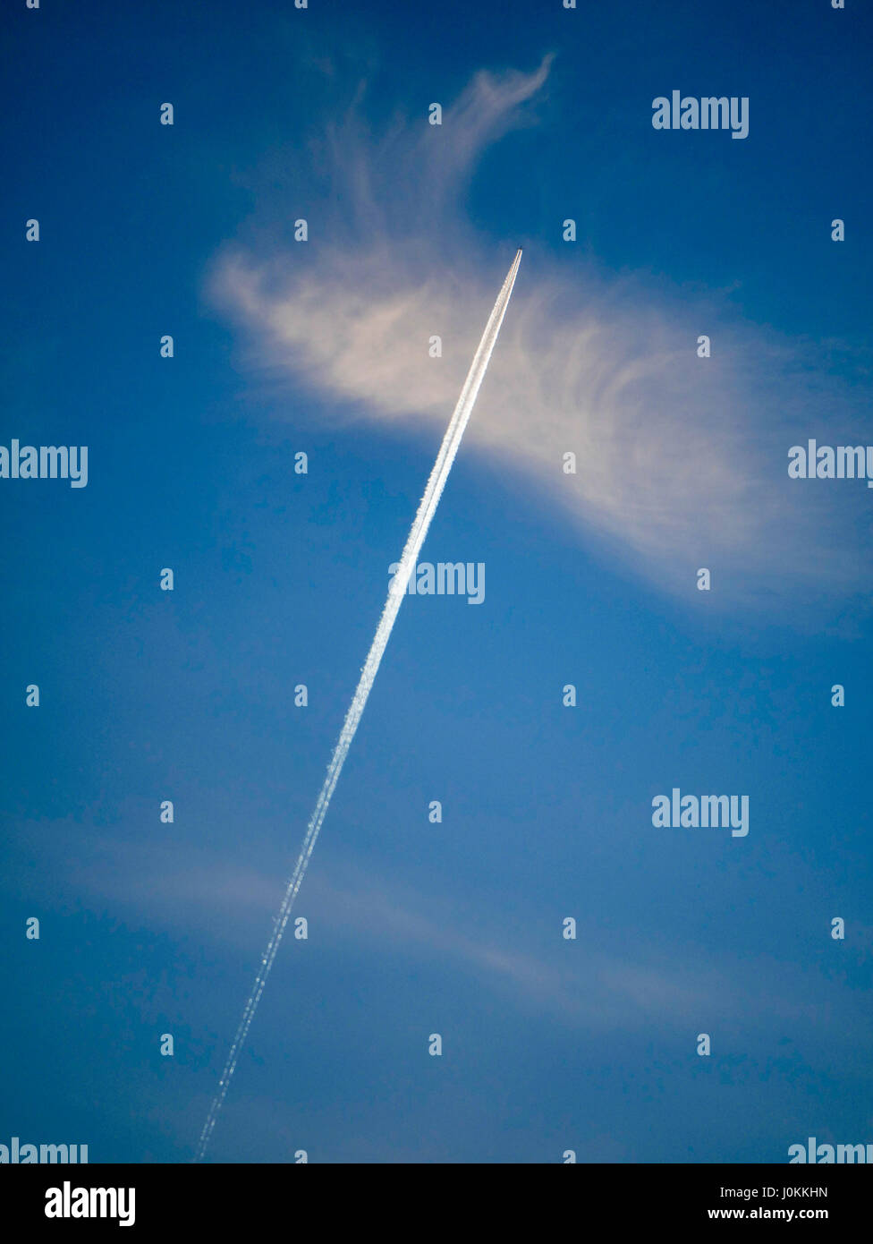 Jetliner leaving contrail, cirrus clouds Stock Photo - Alamy