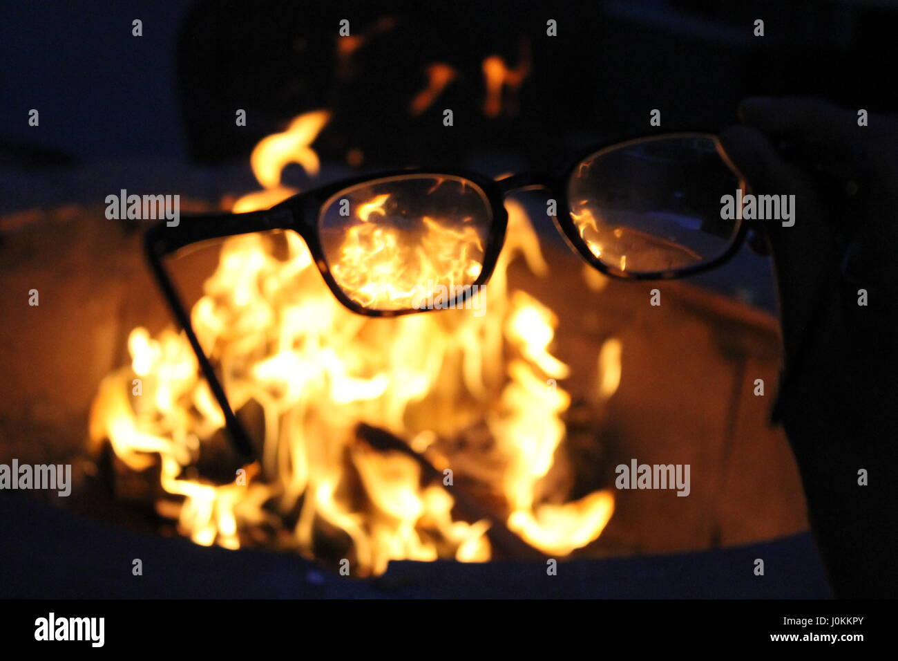 Glasses focused with fire in background Stock Photo - Alamy