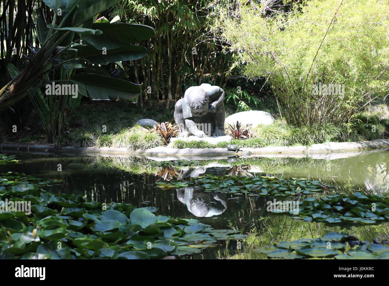 Reflective pond with a statue Stock Photo - Alamy