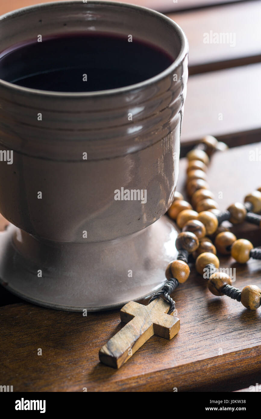 Rosary beads and cup of wine on wooden table Stock Photo - Alamy