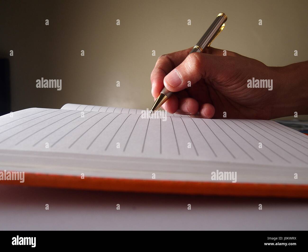 Hand with a pen writing on a page on a notebook Stock Photo - Alamy