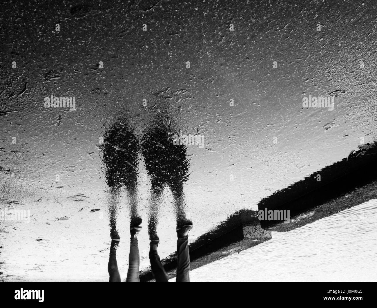 Reflection of people walking along street in the rain Stock Photo - Alamy