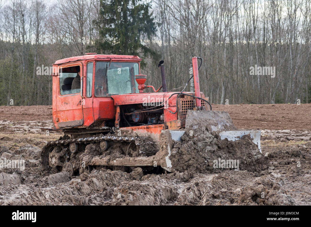Crawler tractor with a plow on the background of rural landscape Stock ...