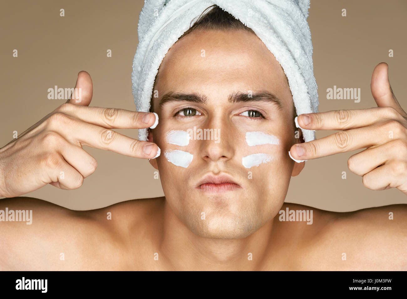 Serious man with moisturizer on the face. Photo of man with perfect ...