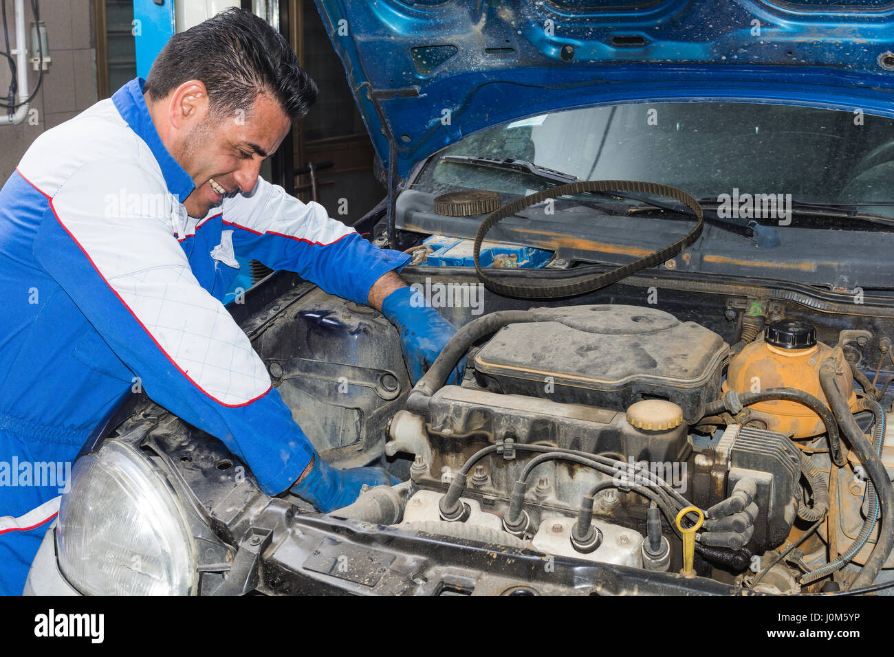 Car mechanic fixing an engine in his garage. copy space Stock Photo - Alamy
