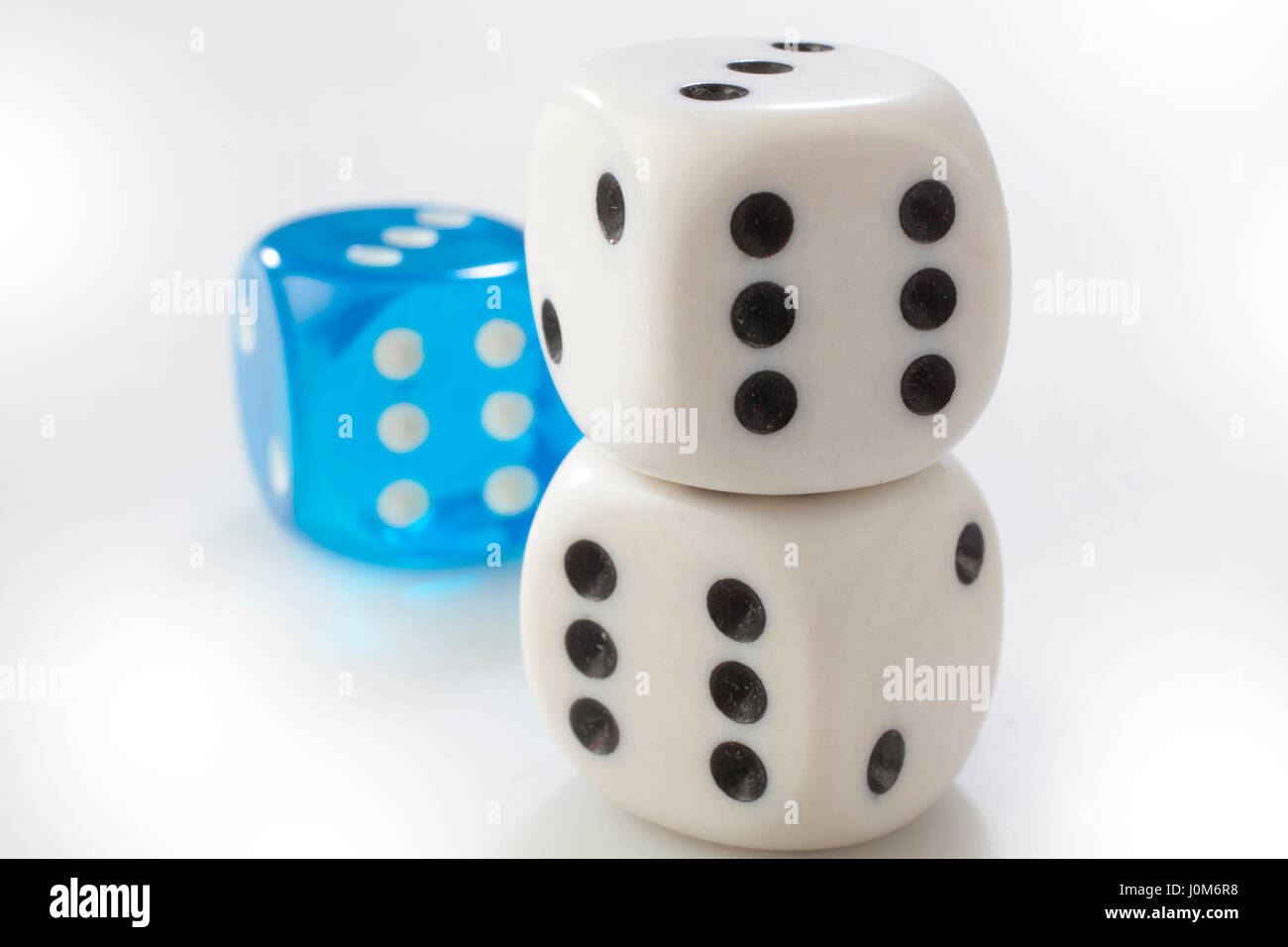 two white and one blue dice on white background Stock Photo - Alamy