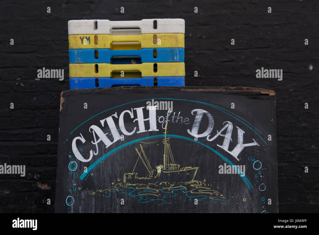 A chalk board sign reading "Catch of the Day" outside a fishmongers in ...