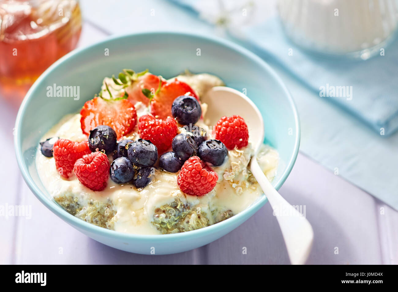Quinoa porridge with summer berries and honey Stock Photo - Alamy