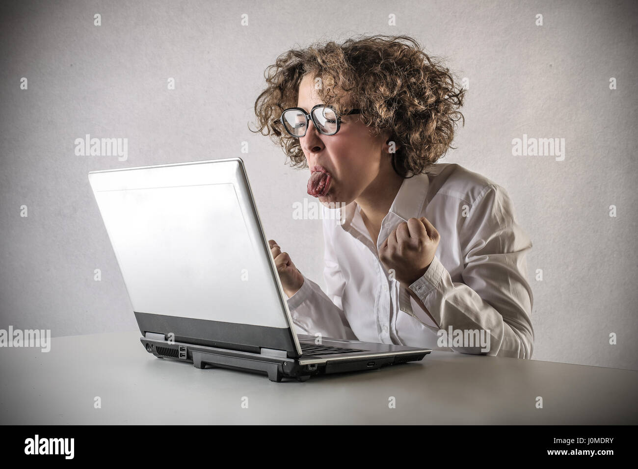 Brunette businesswoman mad in front of laptop Stock Photo - Alamy