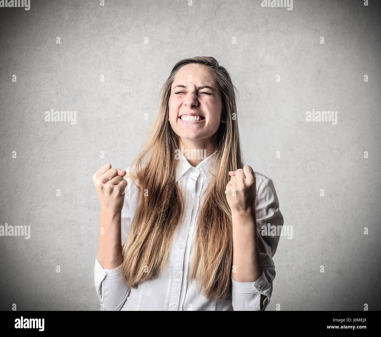 Blond woman cheering inside Stock Photo - Alamy
