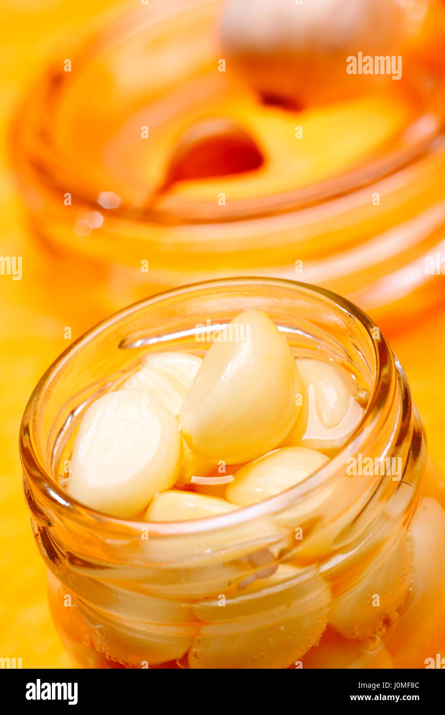 Preserved garlic in opened jar with unfocused background Stock Photo ...