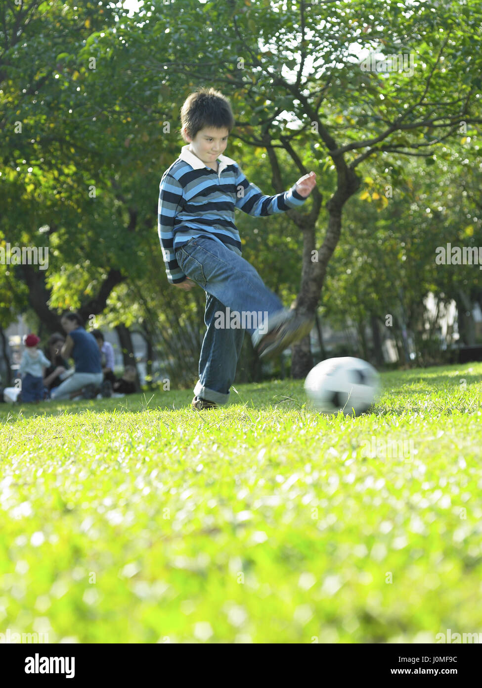 Black child kicking ball hi-res stock photography and images - Alamy