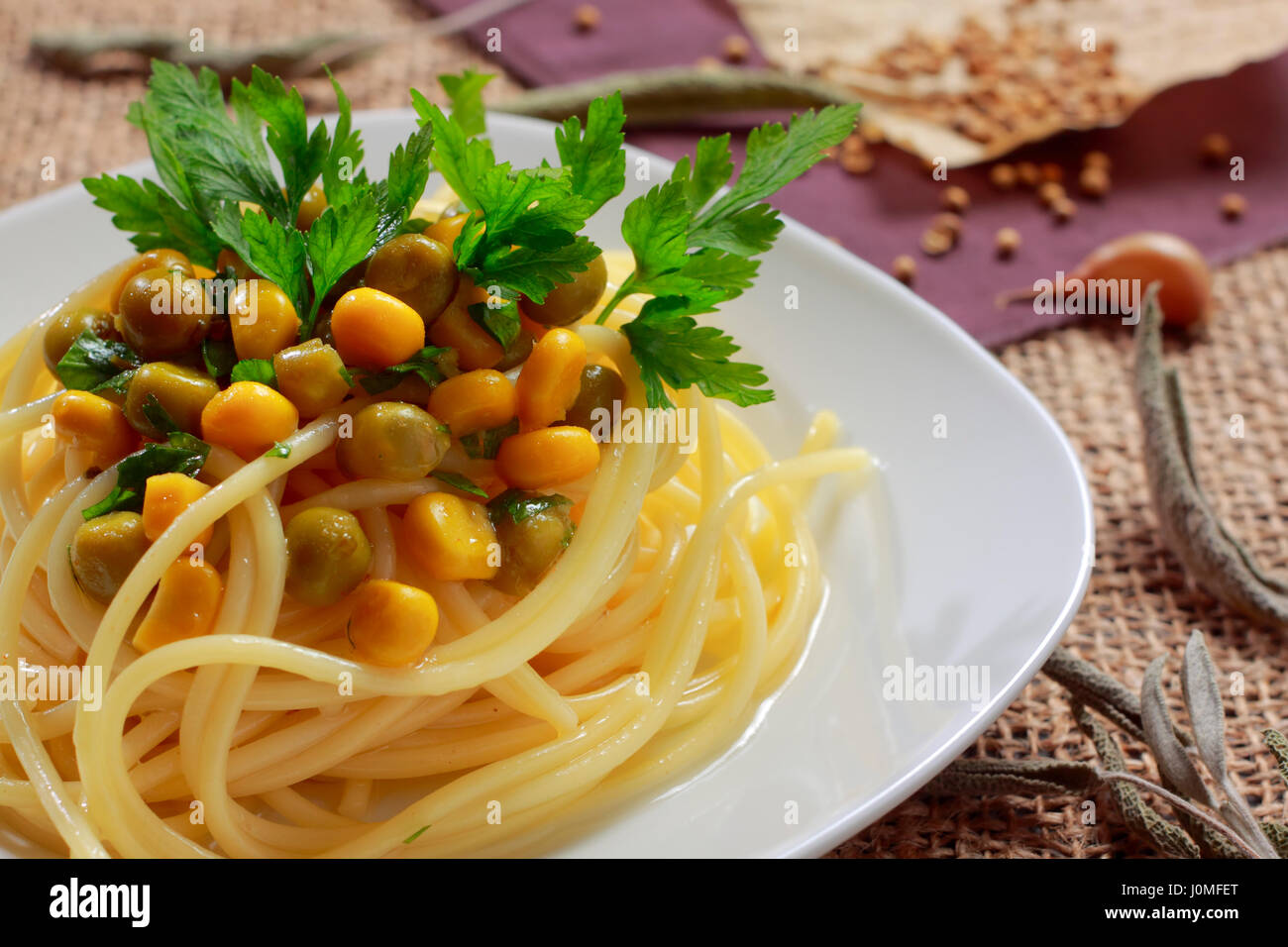 Spaghetti with green peas (preserved), sweetcorn and parsley leaves on ...
