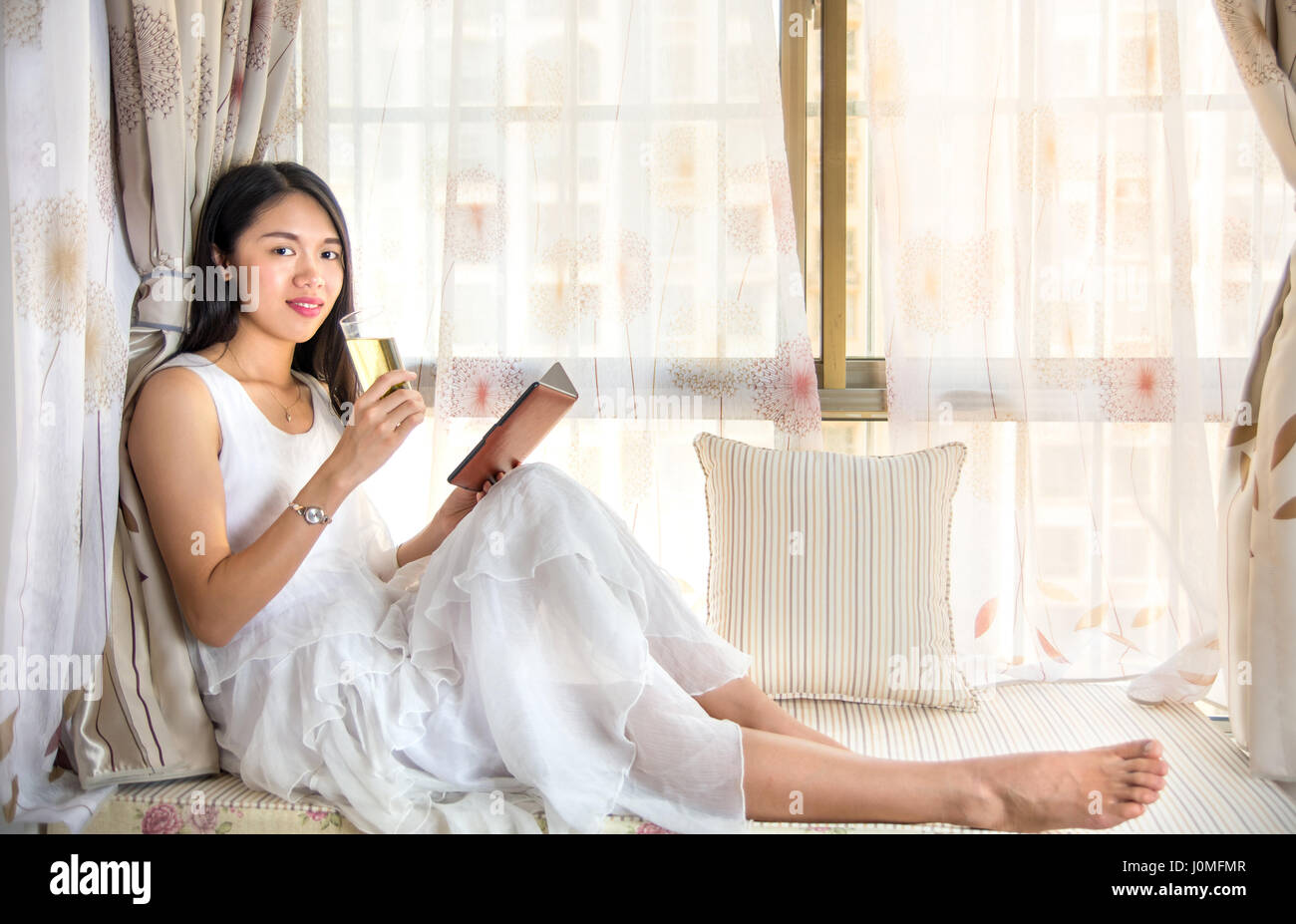 Girl having tea by the bay window Stock Photo - Alamy