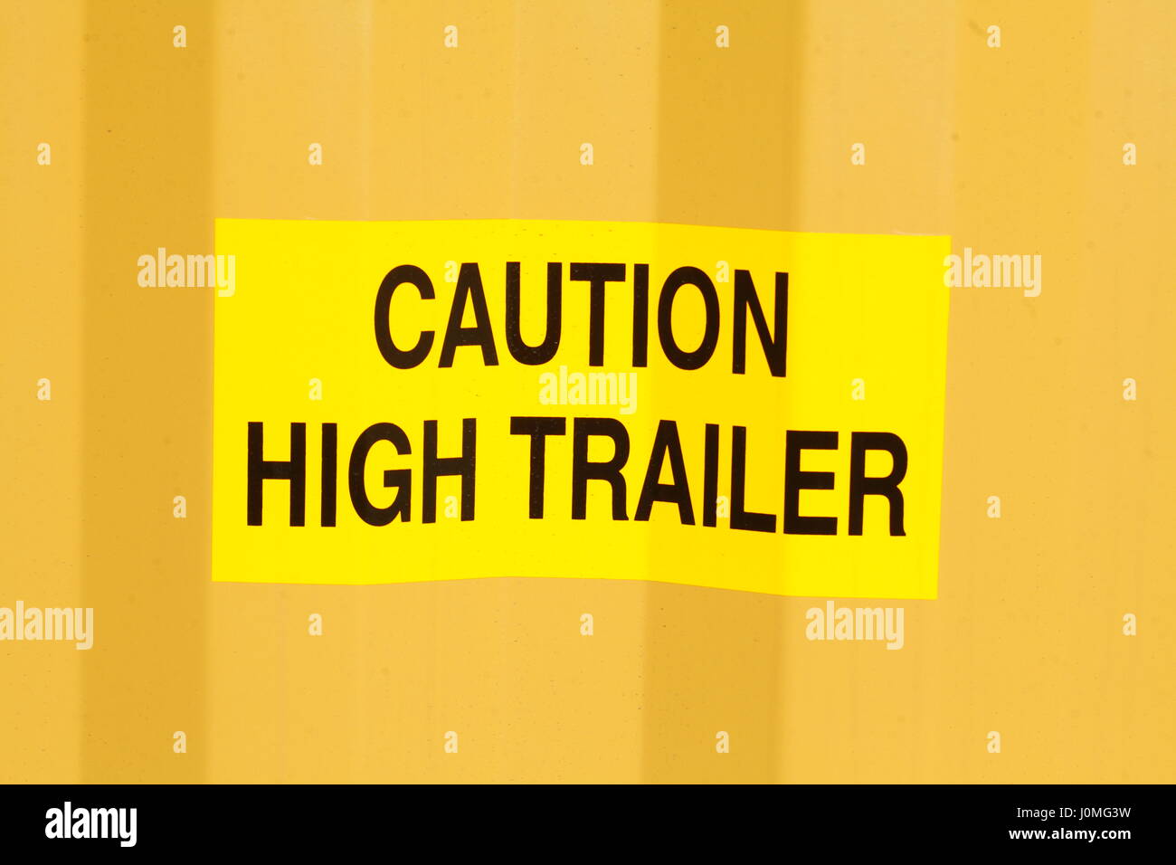Sign Caution high Trailer on a yellow Container Stock Photo - Alamy