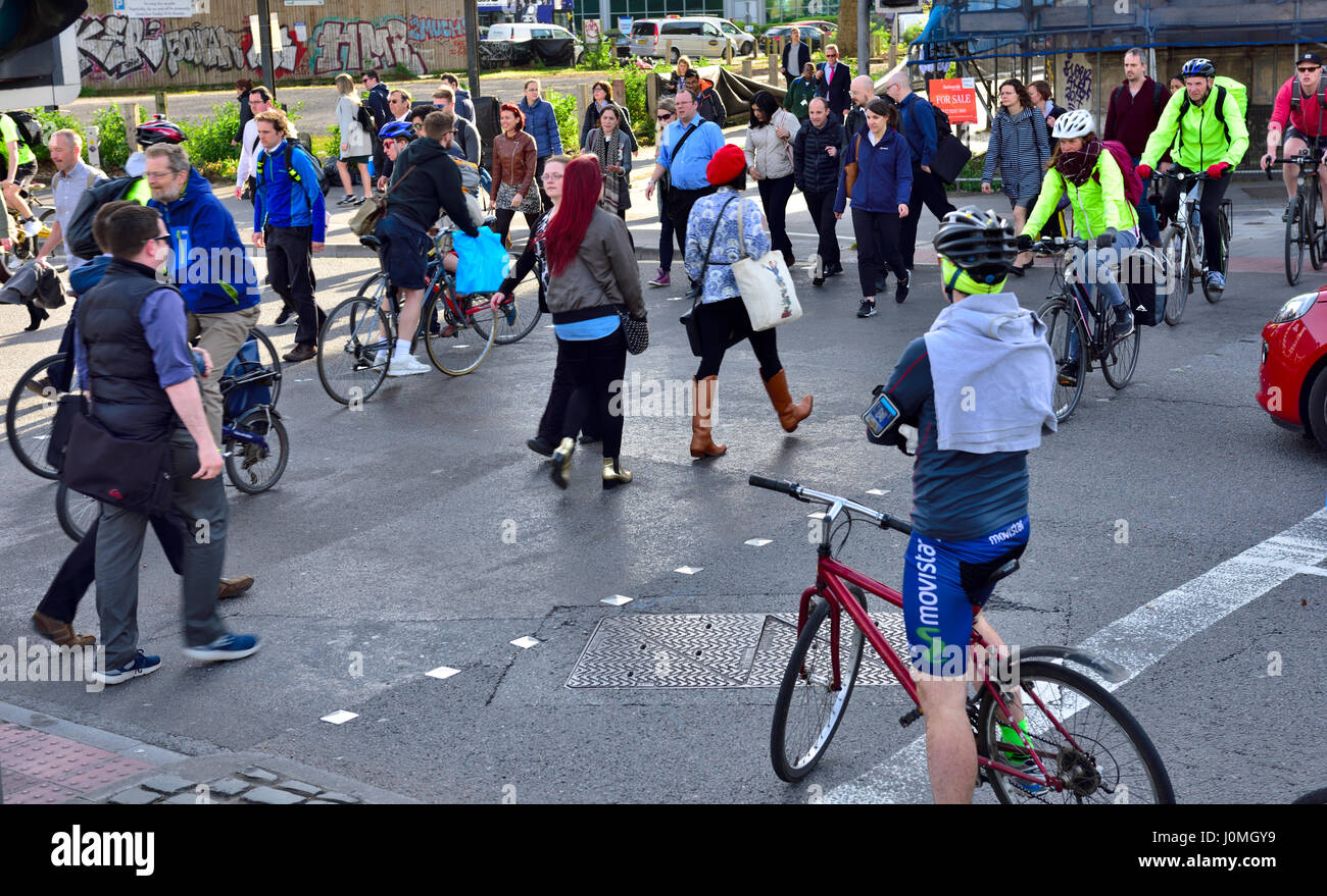 Pedestrians and cyclists crossing the road at intersection with green light, Bristol, England ...